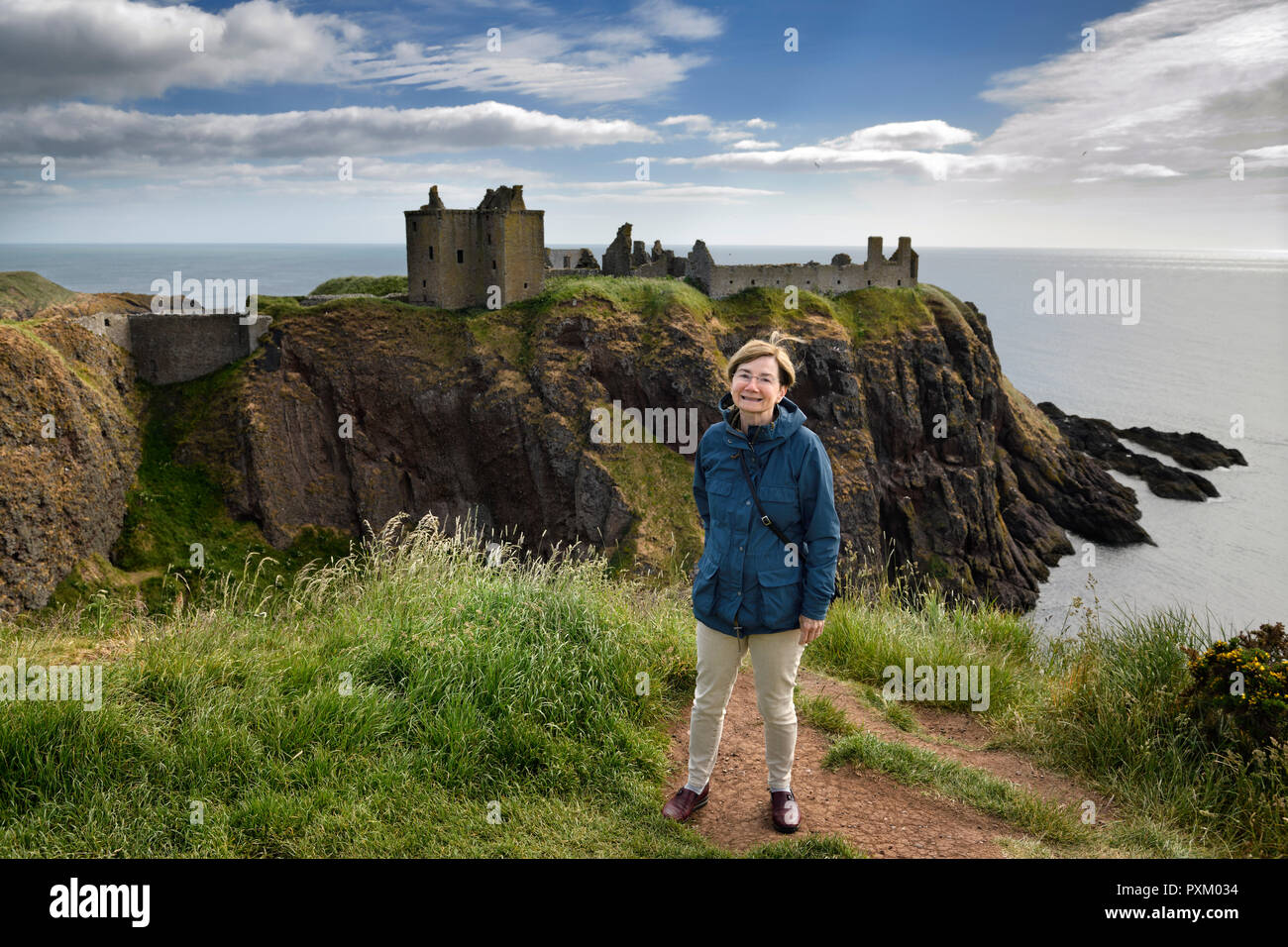 Scottish female tourist visitor at top of cliff above Old Hall Bay with ...