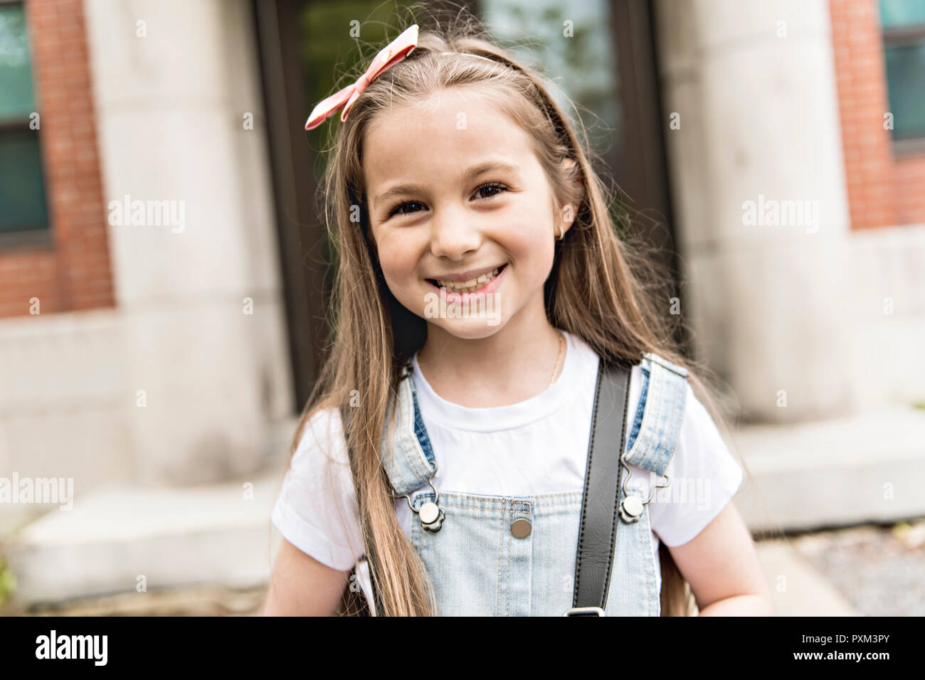 A Portrait of cute girl with backpack outside of school Stock Photo - Alamy