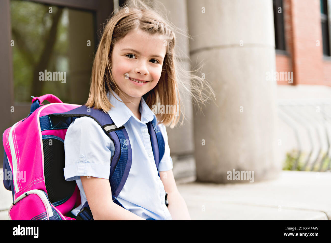 A Portrait of cute girl with backpack outside of school Stock Photo - Alamy