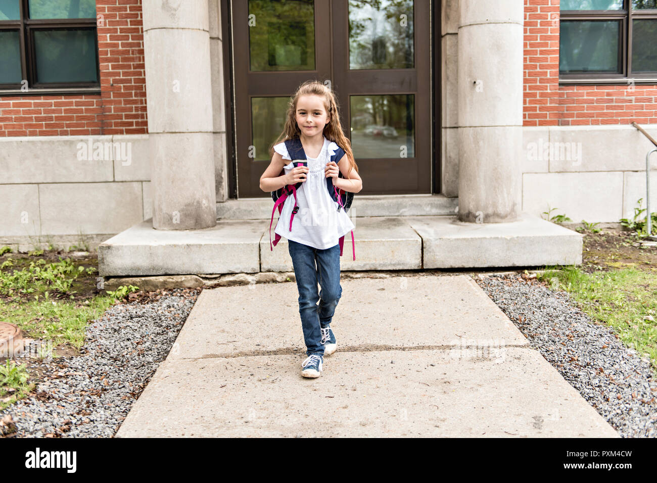 A Portrait of cute girl with backpack outside of school Stock Photo - Alamy