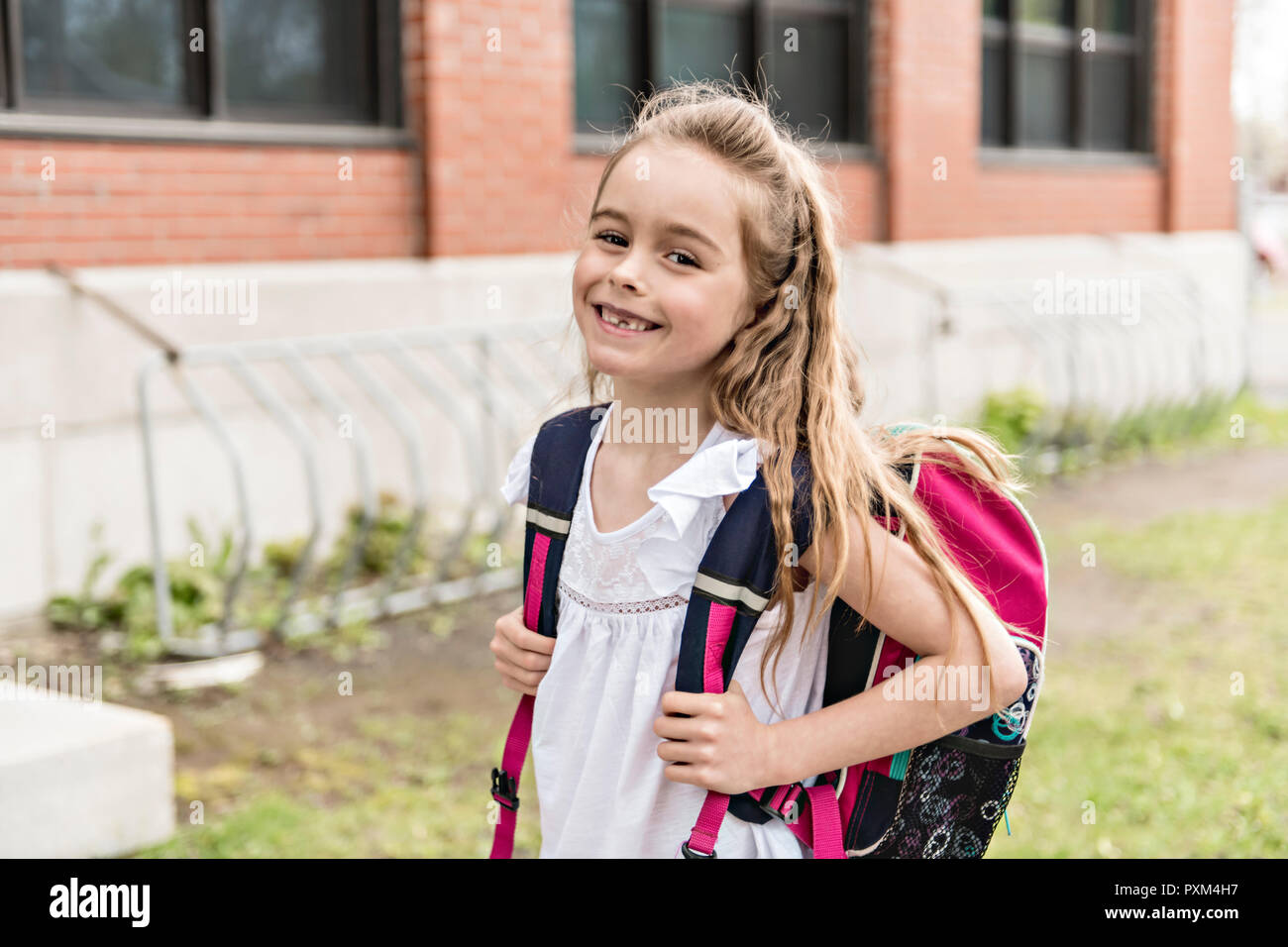A Portrait of cute girl with backpack outside of school Stock Photo - Alamy