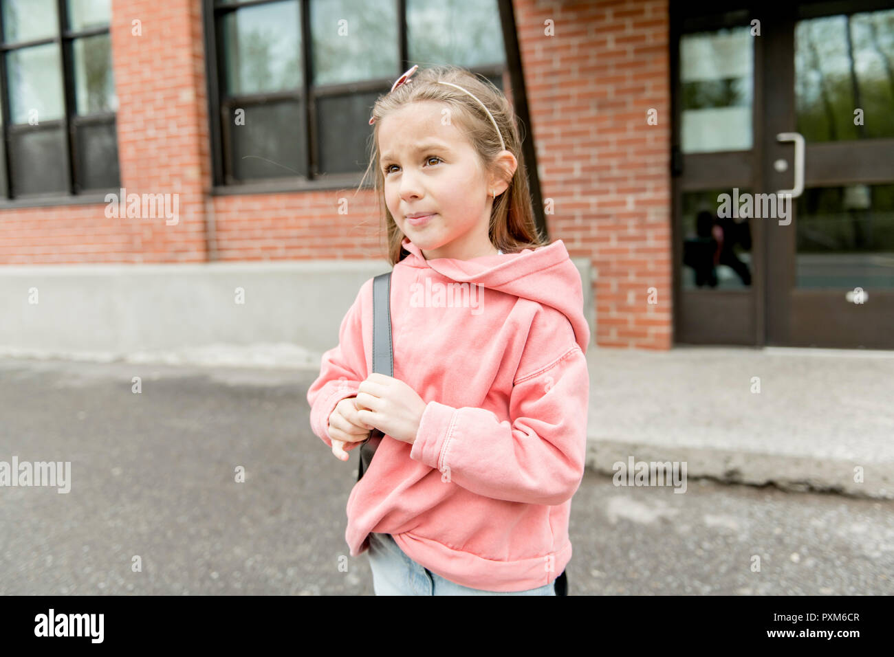 A Portrait of cute girl with backpack outside of school Stock Photo - Alamy