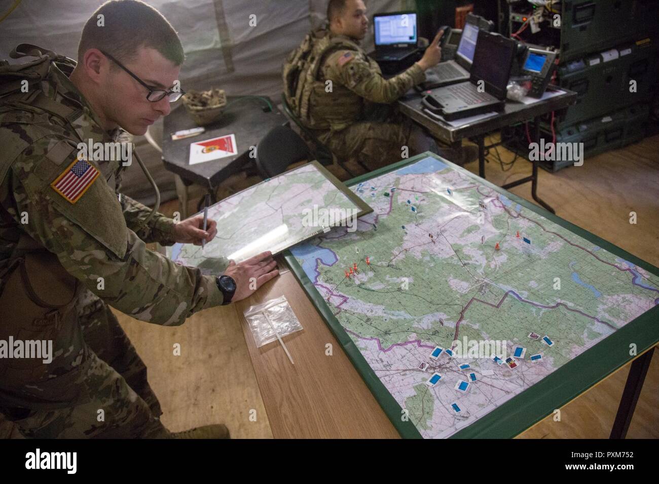 A Battle Group Poland U.S. Soldier prepares maps in the tactical ...