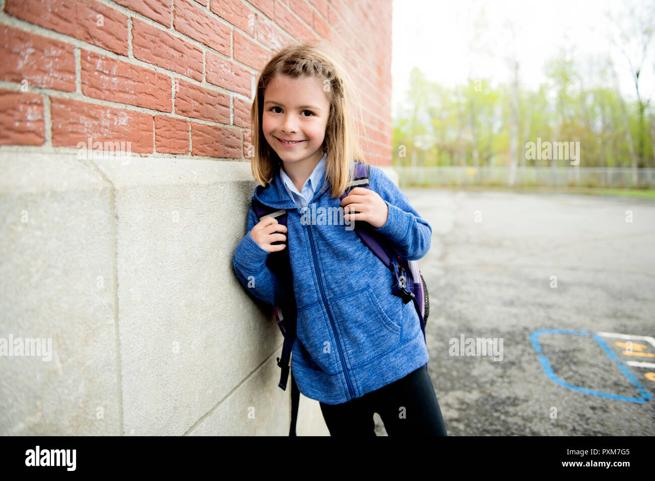 A Portrait of cute girl with backpack outside of school Stock Photo - Alamy