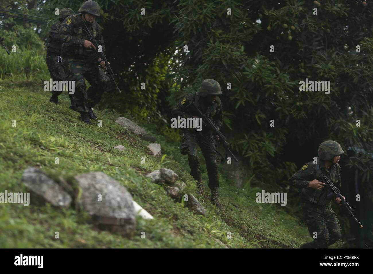 Belizean Defence Force soldiers assault down a hill while conducting a ...