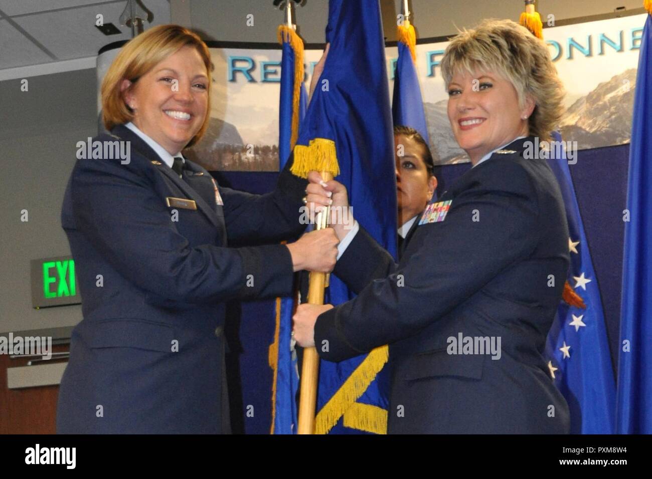 Brig. Gen. Ellen Moore (left), the HQ ARPC commander, passes the HQ RIO guidon to the ...