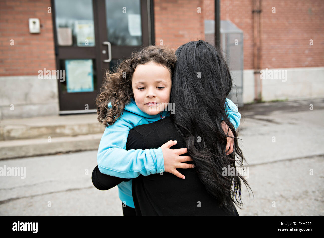 A girl and his mother hugging outside at school Stock Photo - Alamy