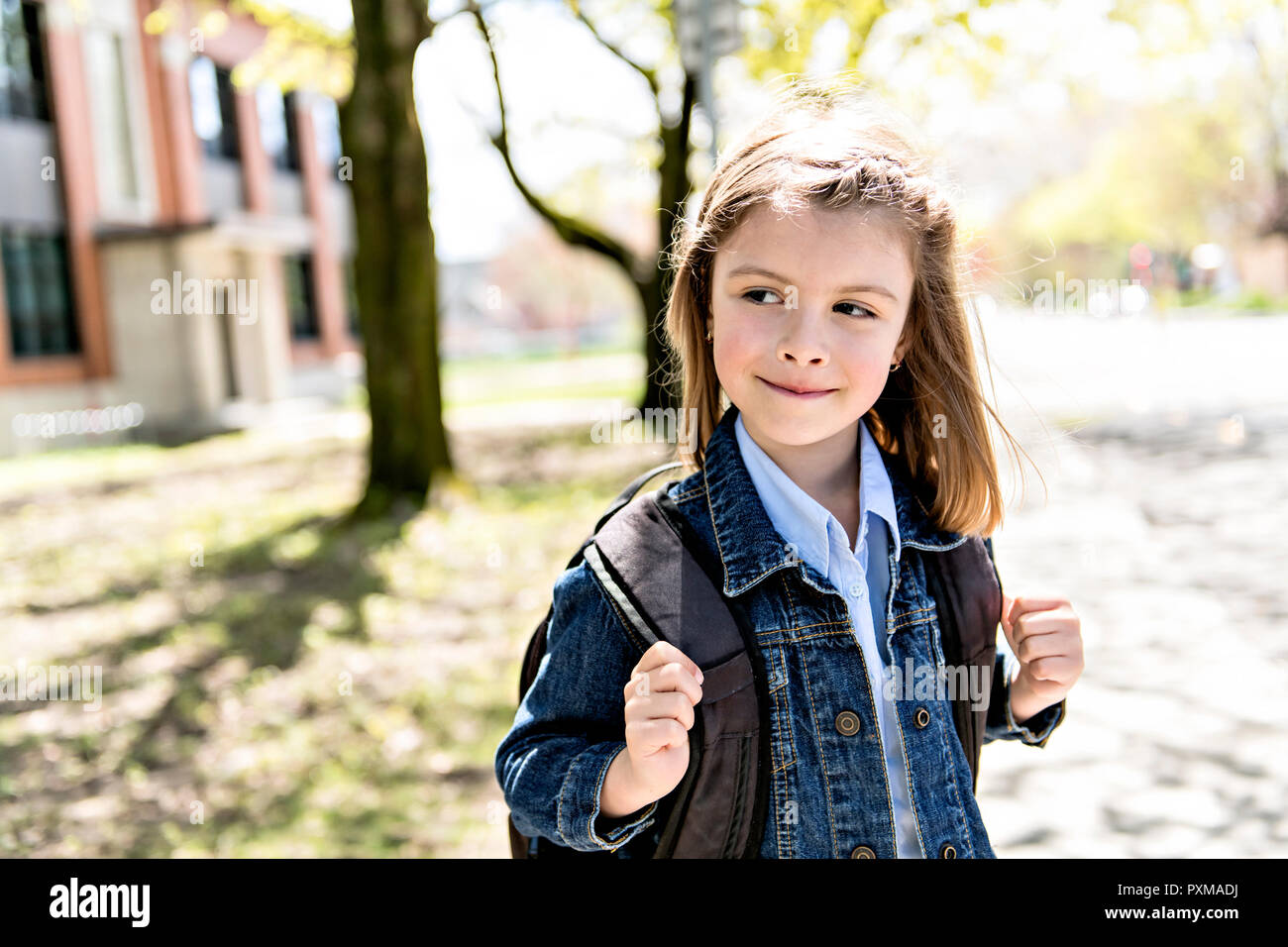 A Portrait of cute girl with backpack outside of school Stock Photo - Alamy
