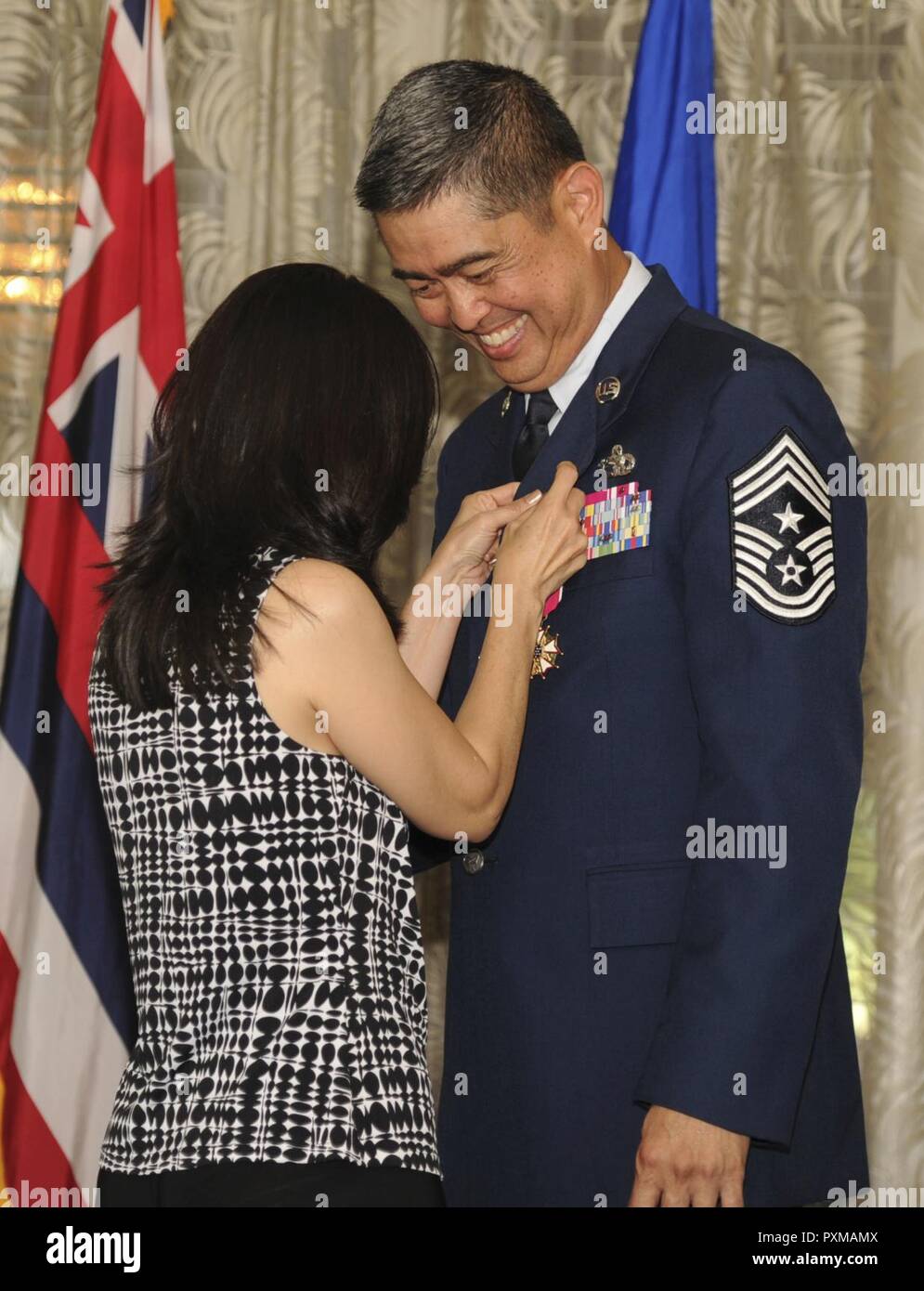 Helen Wong places the retirement pin on Chief Master Sgt. Brian Wong’s , Fourth Air Force ...