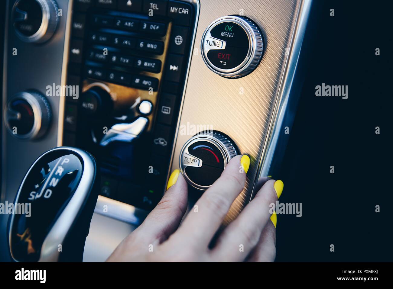 Woman regulating car interior temperature on car automatic air ...