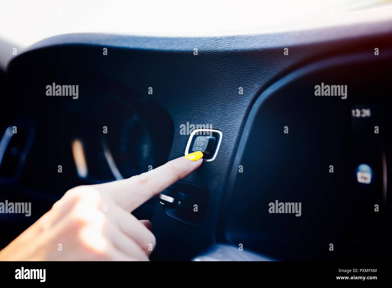 Woman starting car engine with start stop engine button. Modern car ...