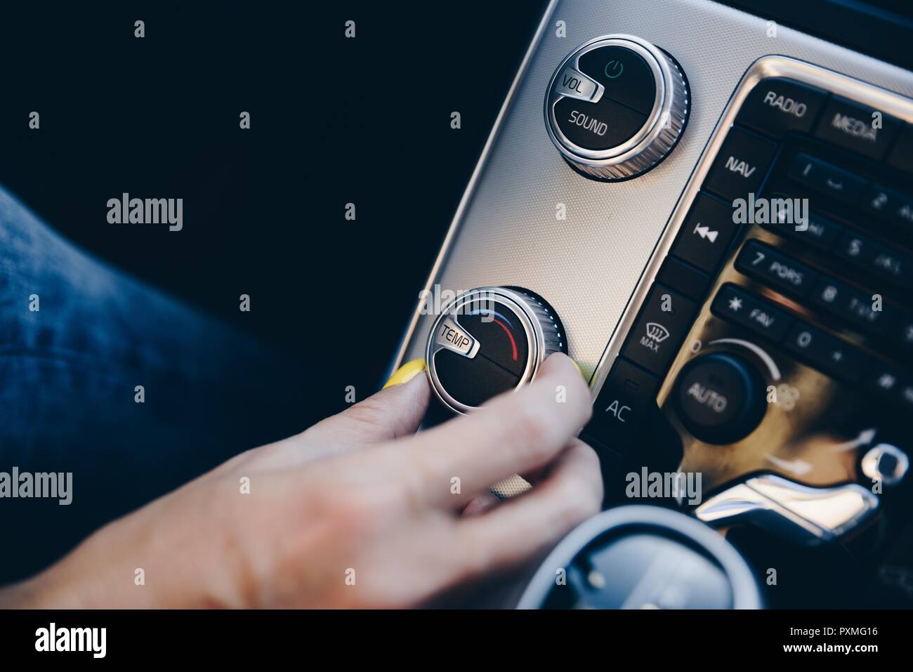 Woman regulating car interior temperature on car automatic air ...
