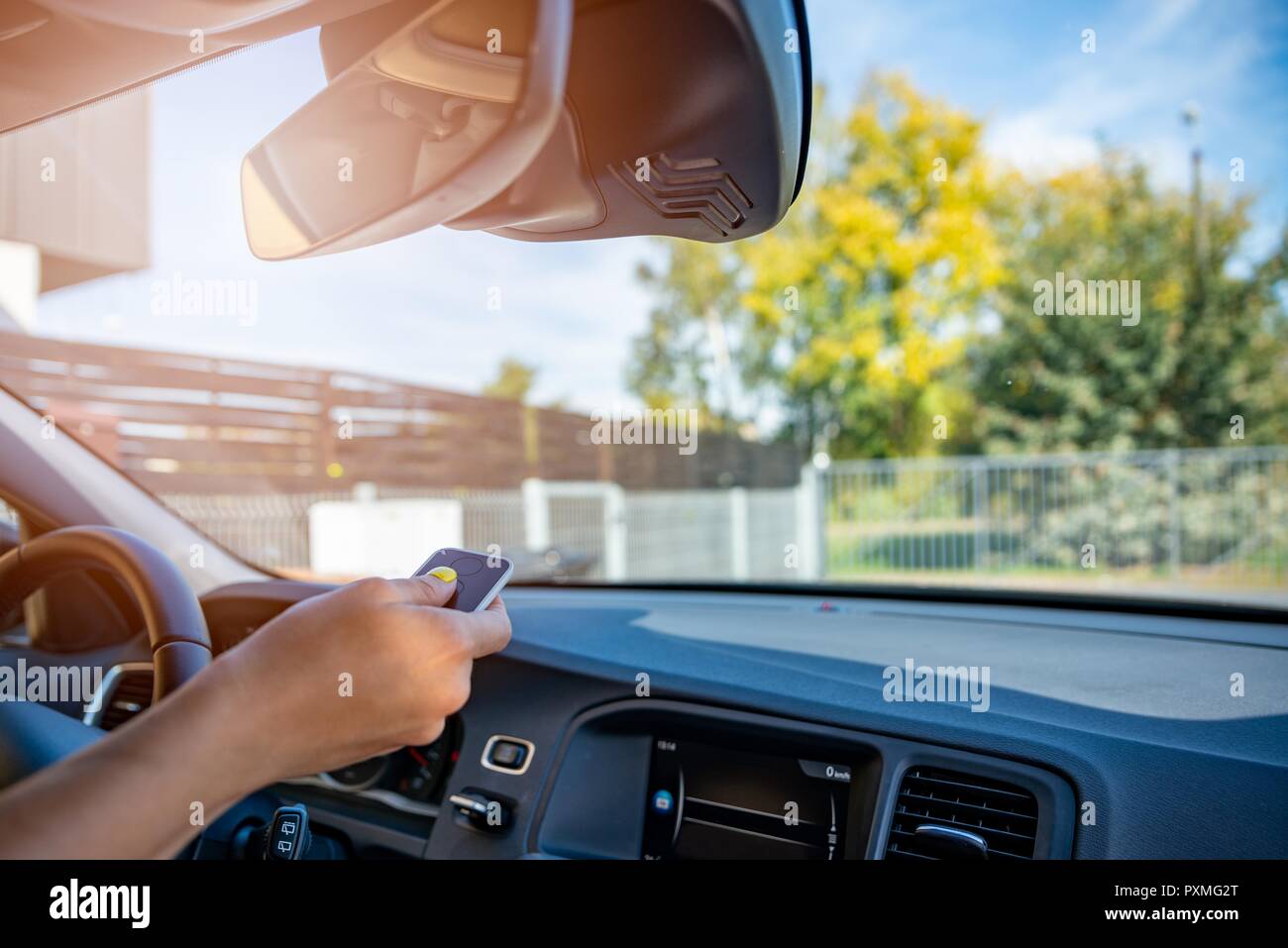 Person opening automatic property gate with remote control from car ...