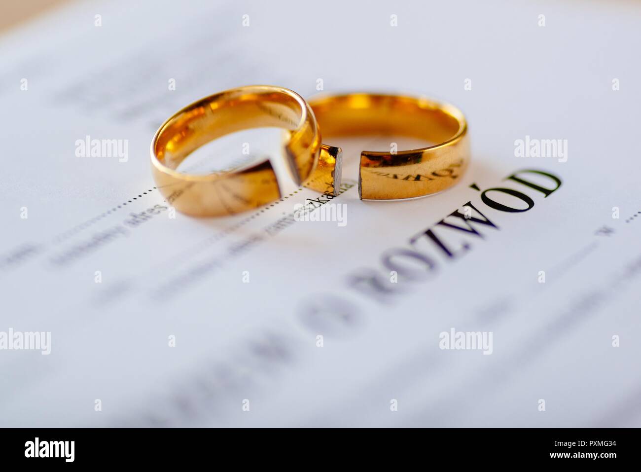 Divorce decree in Polish language and two broken wedding rings. Divorce ...