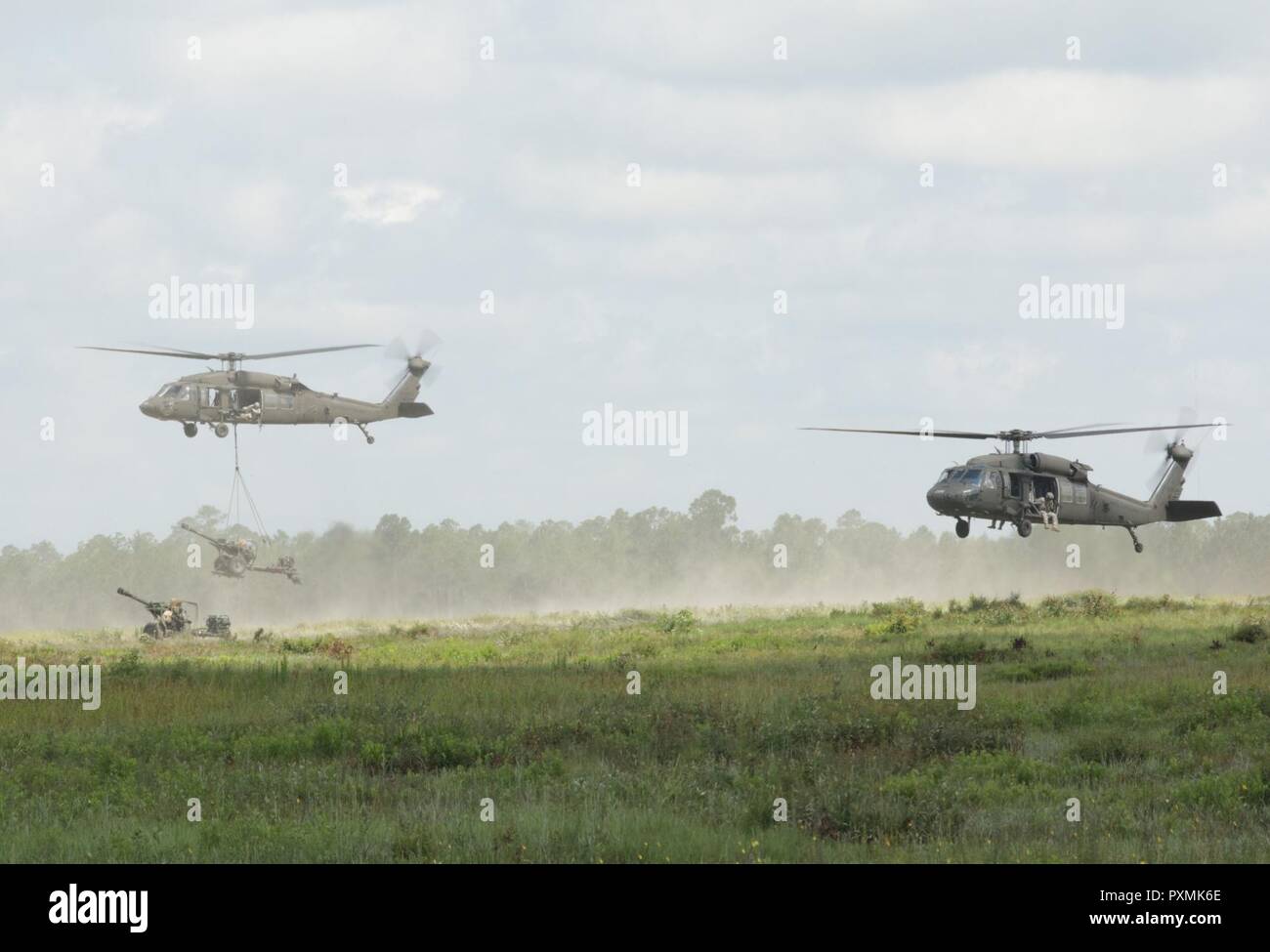 Sikorsky UH-60 Blackhawk helicopters lower 119A3 Howitzer cannons June ...