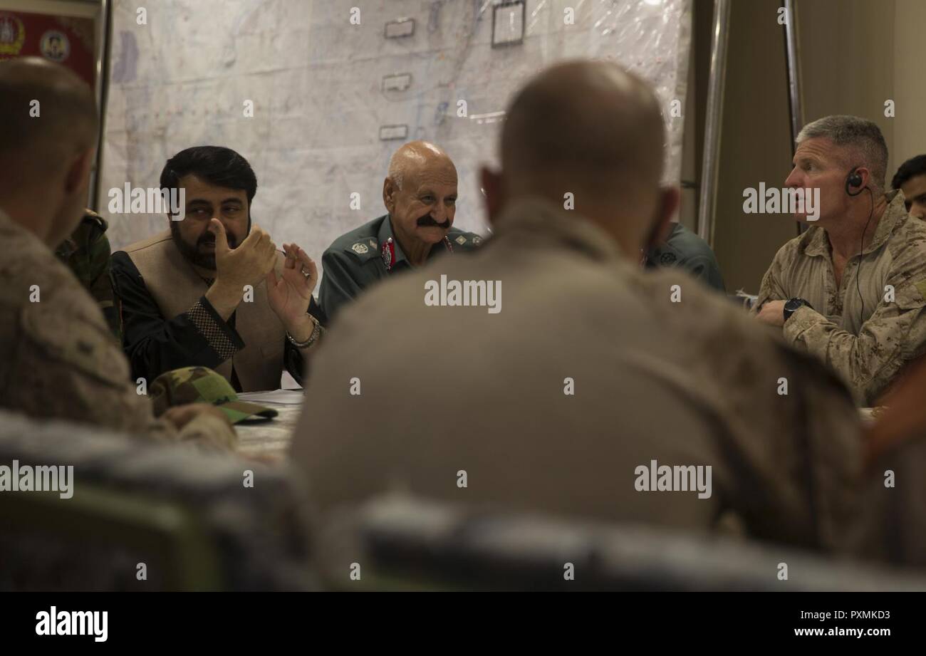 Governor Hayatullah Hayat, left, the governor of Helmand Province, sits ...