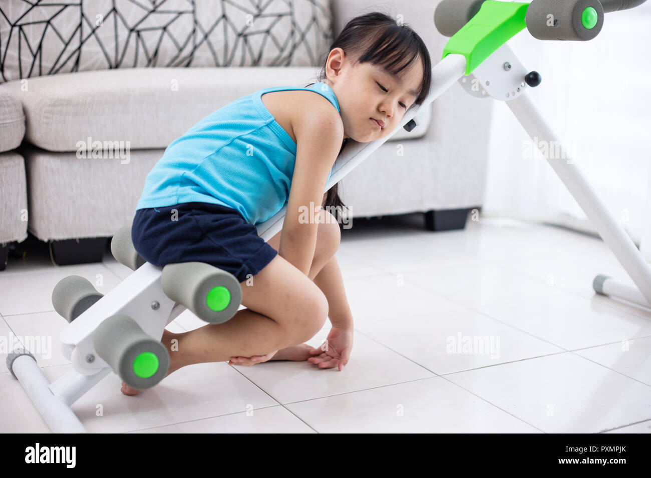 Asian Chinese little Girl playing workout machine in the living room at ...