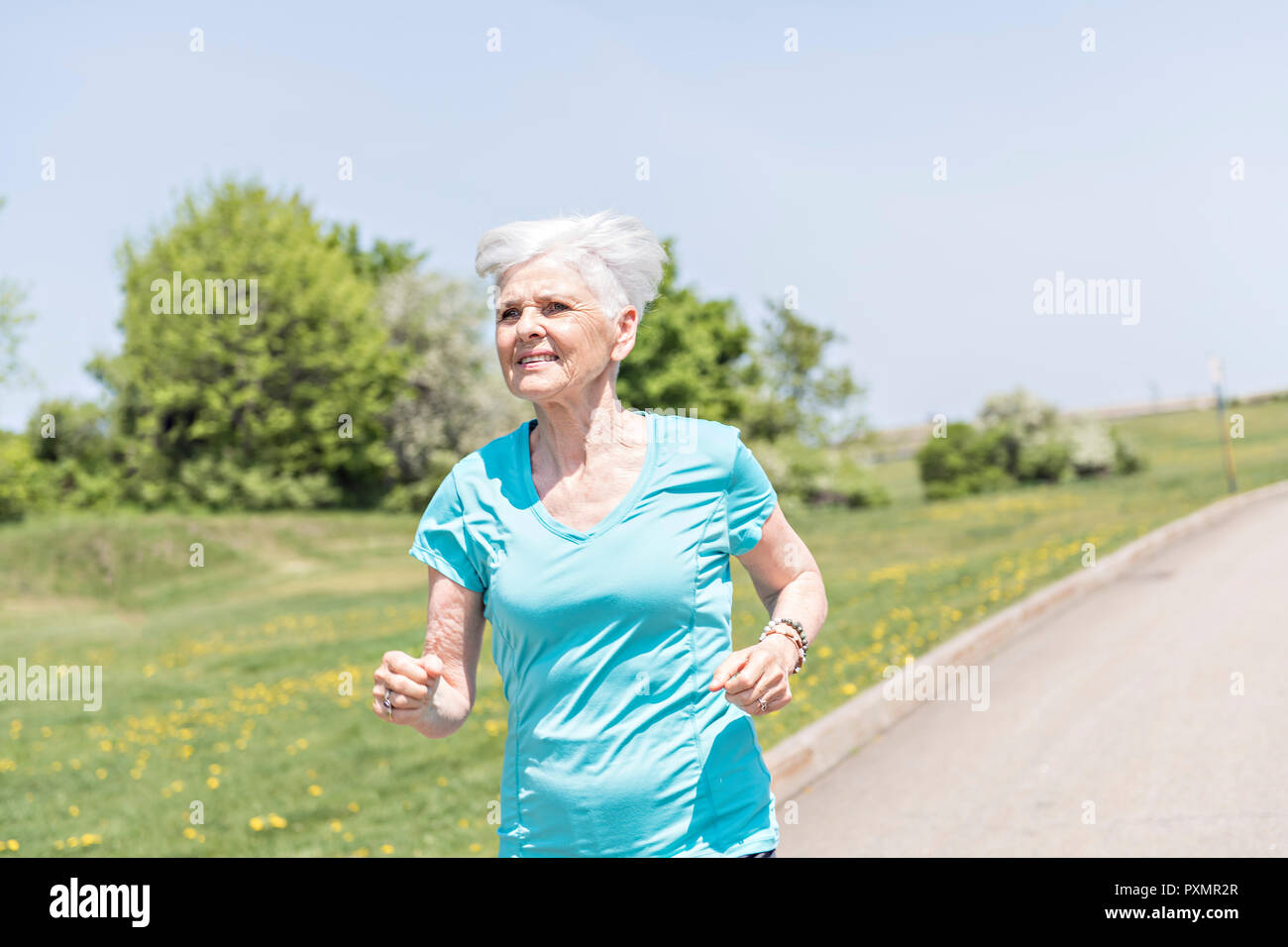 Older woman jogging in park hi-res stock photography and images - Alamy
