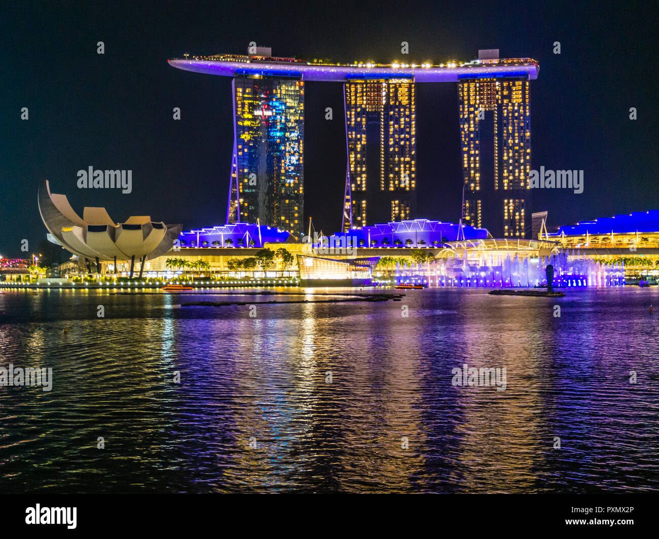 View at night across Singapore Marina Bay towards the illuminated Marina Bay Sands hotel Stock ...