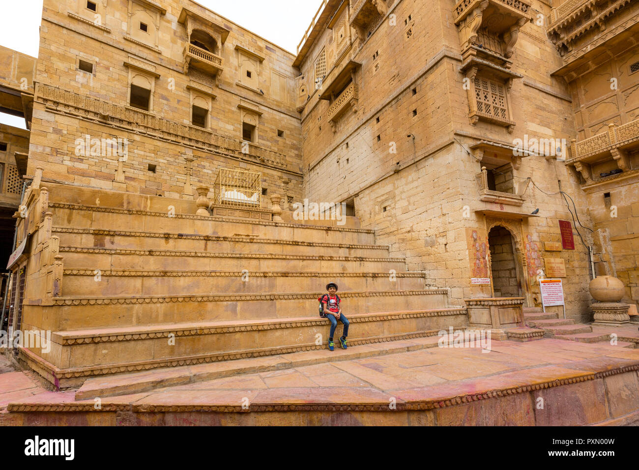 A young Indian boy sitting on the steps inside the Jaisalmer fort in ...