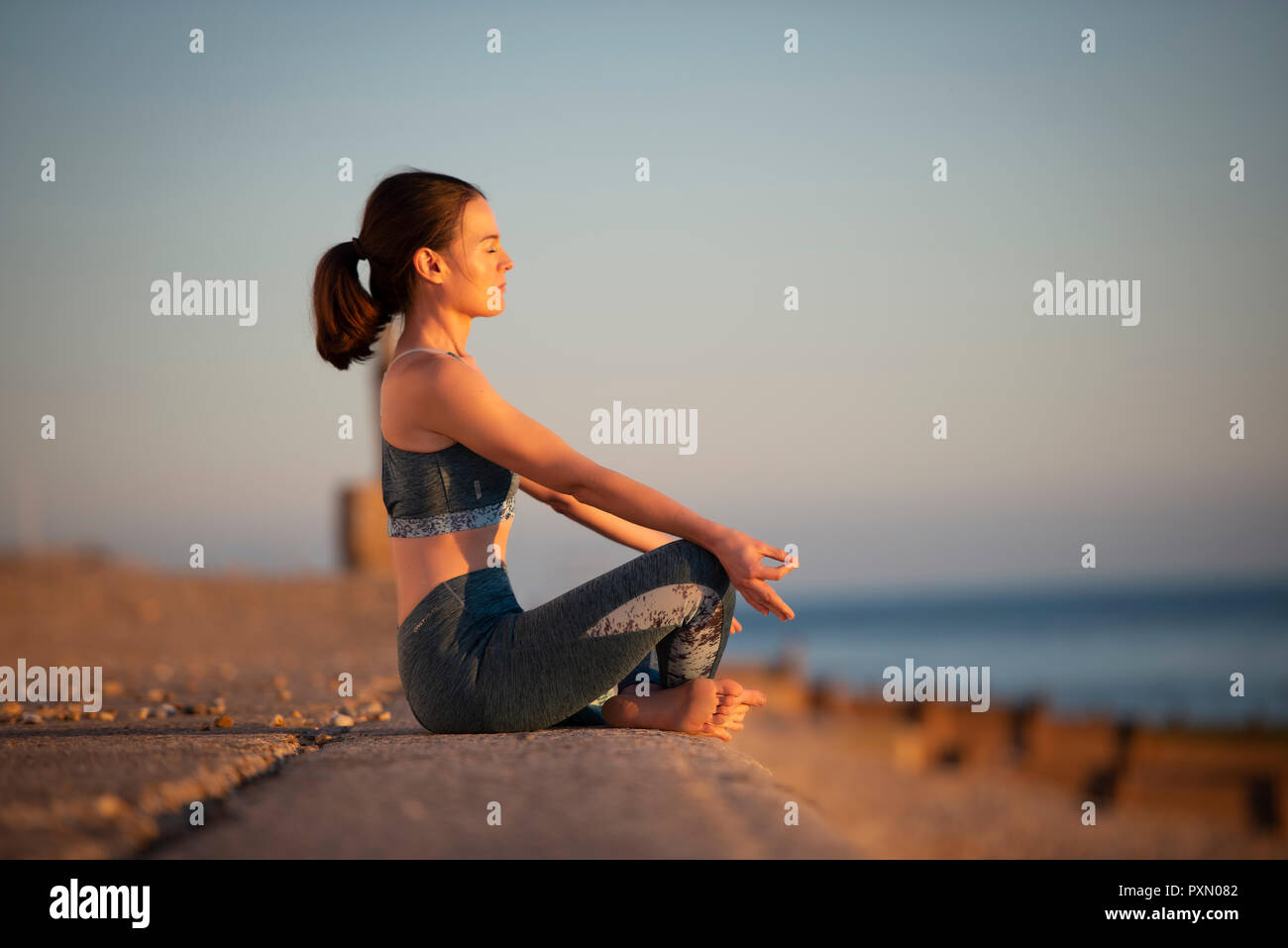 woman sitting crossed legged, meditating Stock Photo - Alamy