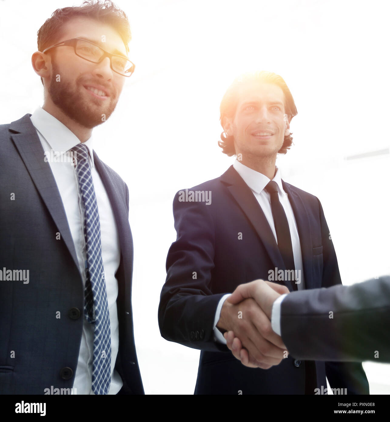 business group welcomes partner with a handshake Stock Photo - Alamy
