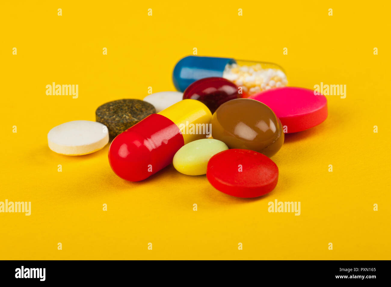 Close up picture of many colored medical drugs on yellow background ...