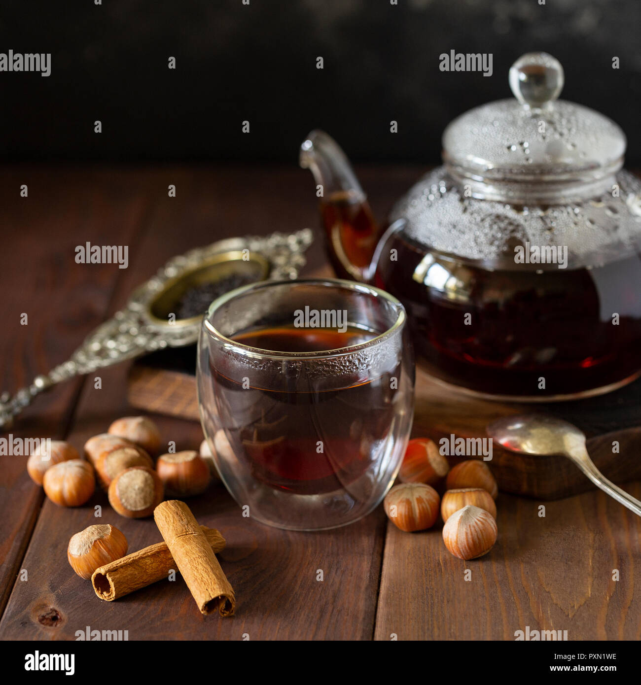 Still life composition. Tea in glass cup with teapot near, vanilla pod ...