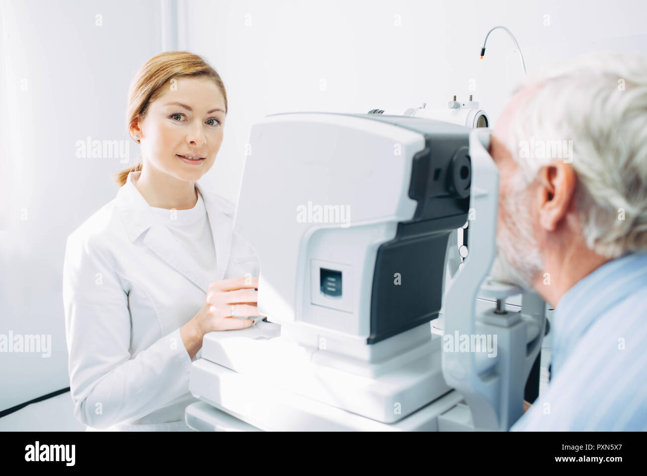 Smiling optometrist while working while working. Eye exam of the ...