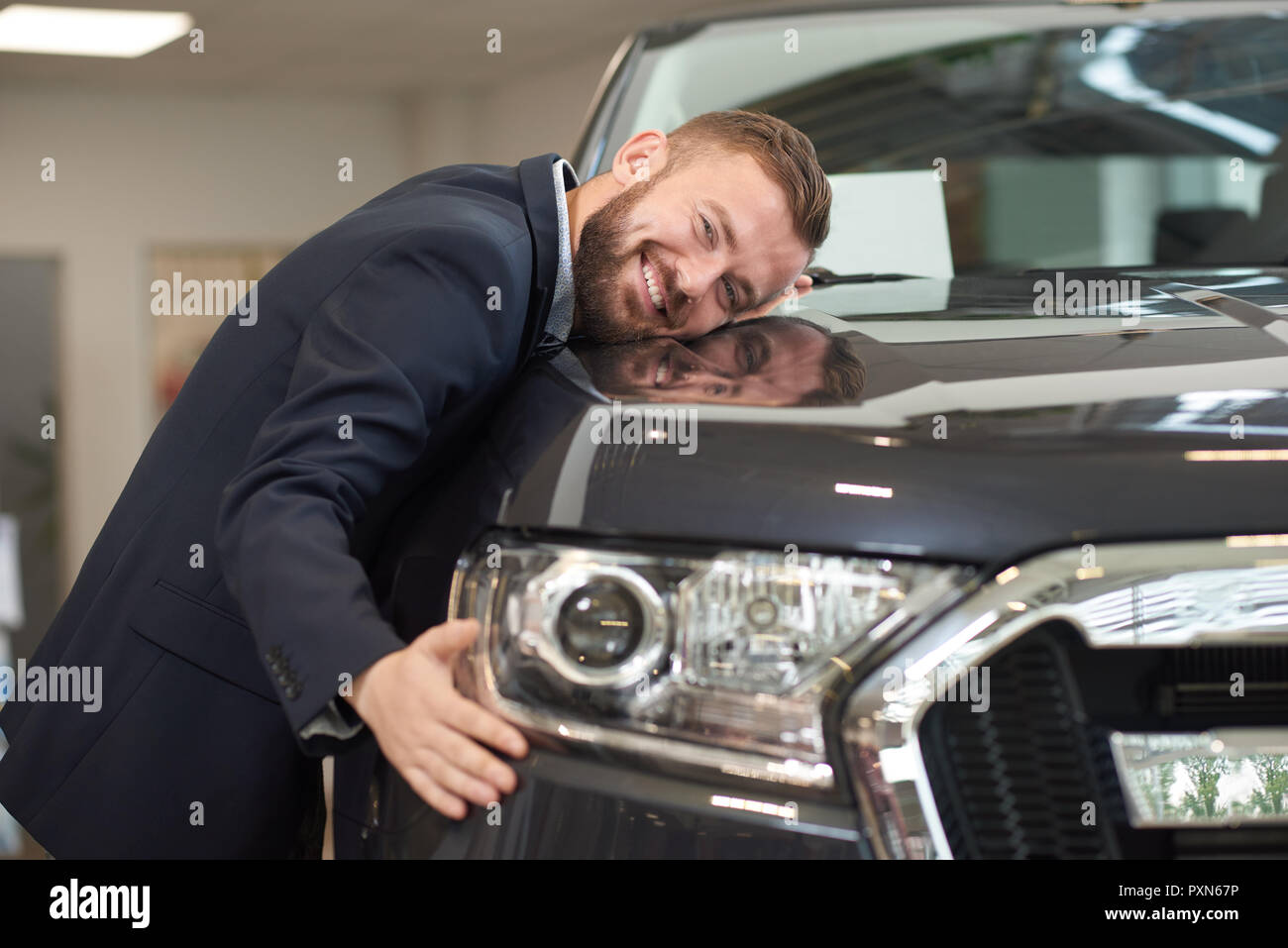 Happy owner of new dark blue automobile posing with vehicle. Handsome ...