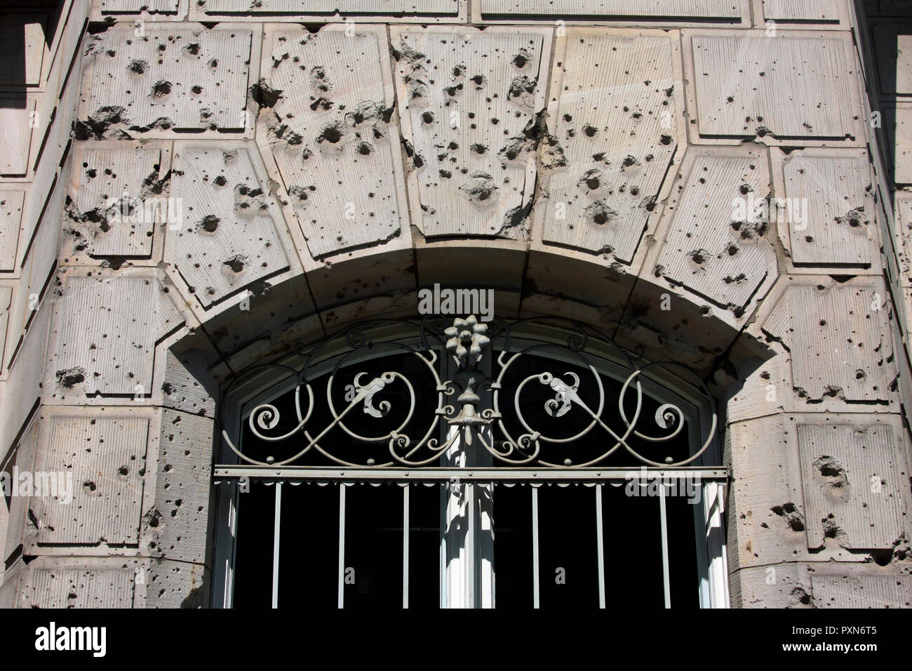 The many bullet holes on the wall of this building act as a reminder of ...