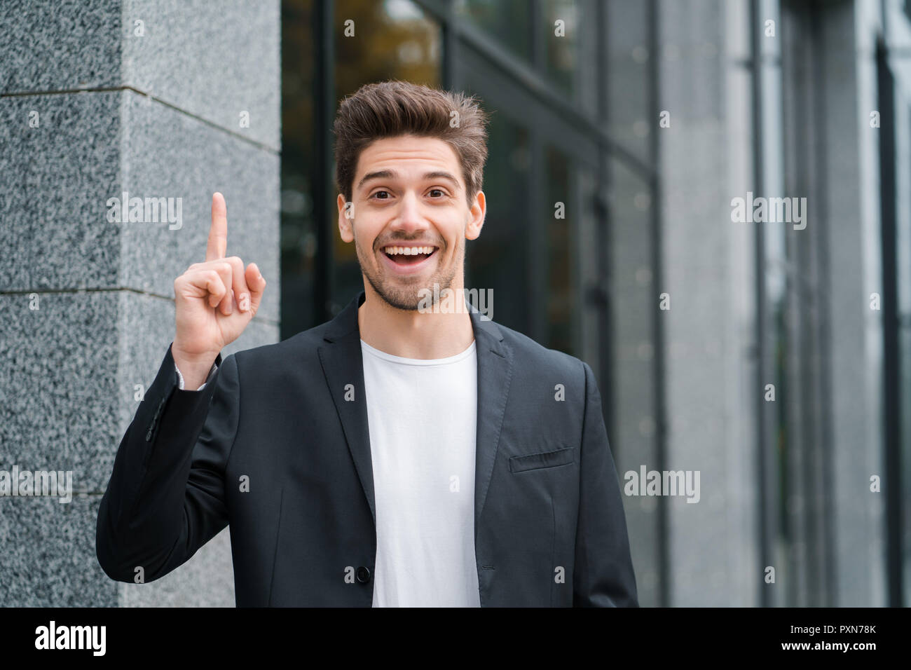 Smiling happy student man showing eureka gesture. Portrait of young ...