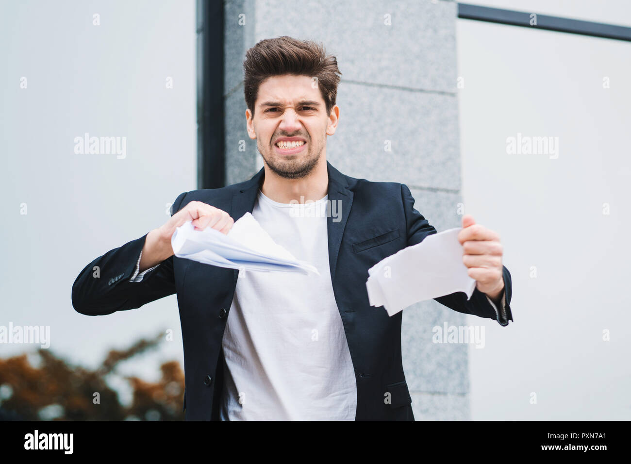 Serious businessman tearing contract in pieces. Angry furious male ...