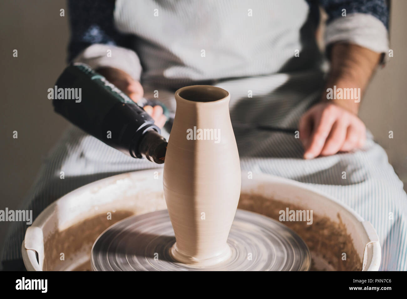 Experienced male potter blows dry the clay, he creating beautiful clay ...
