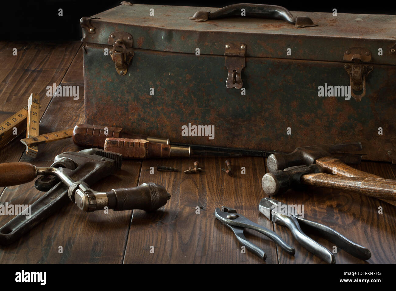 Antique tools and grungy toolbox on dark wood surface Stock Photo - Alamy