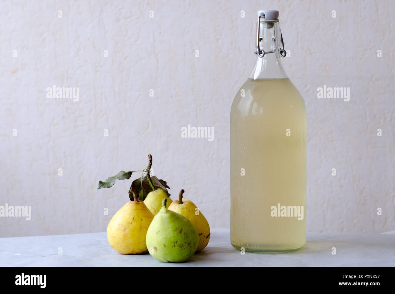 Pears and juice in a bottle on light background Stock Photo - Alamy