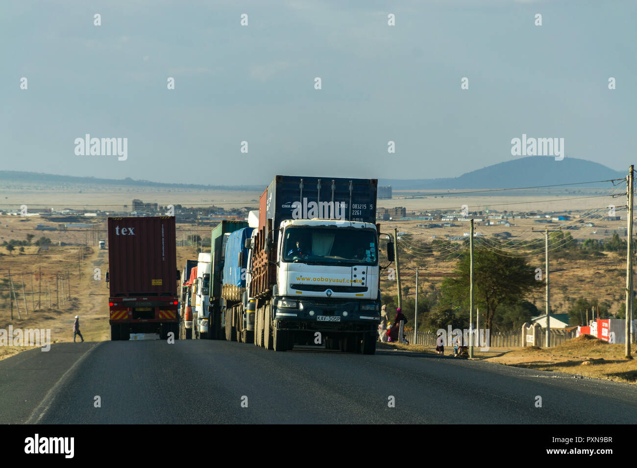 Trucks driving up a hill transporting goods on Mombasa road, Kenya ...