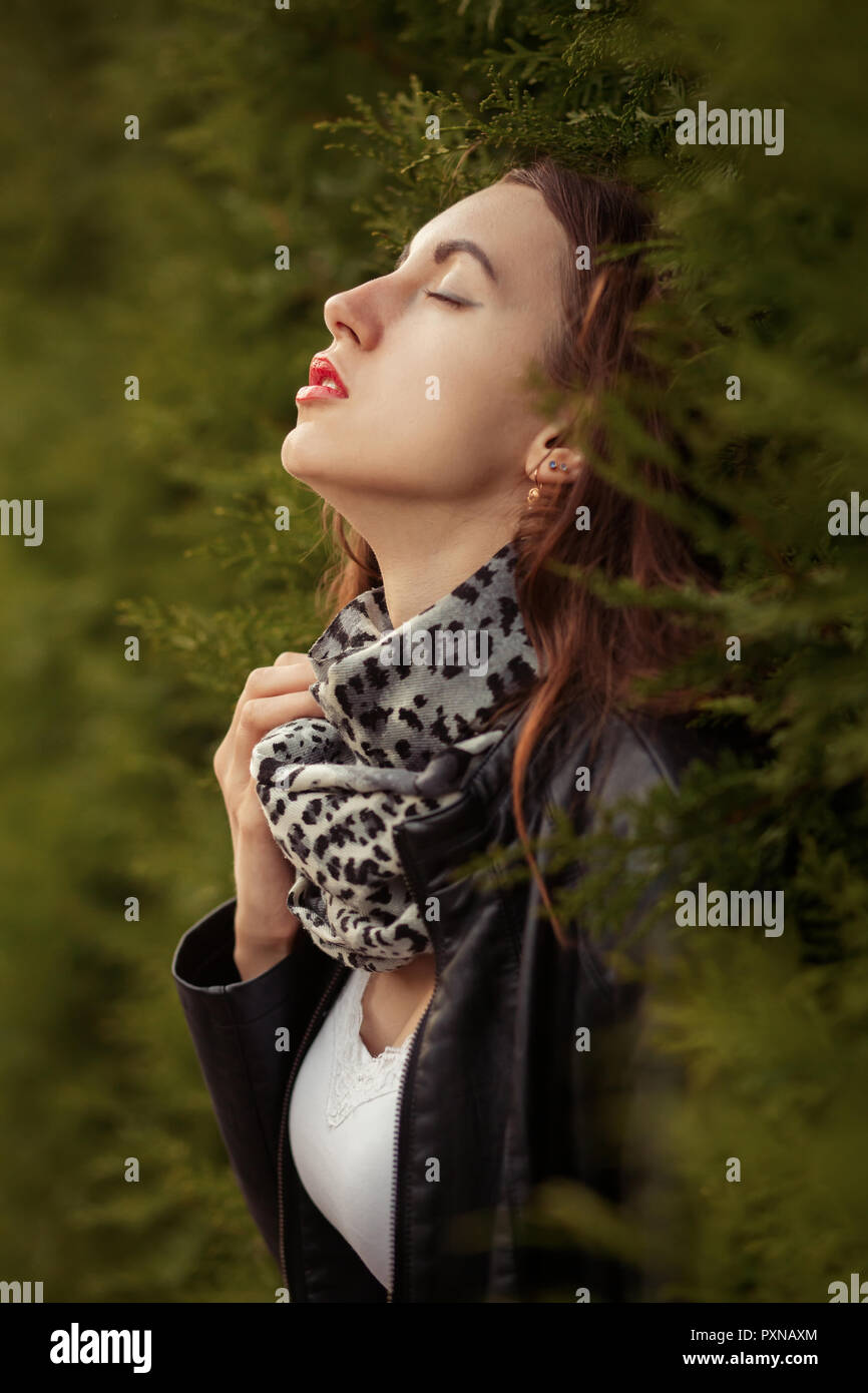 sensual aroused young woman in leather coat near green grass wall Stock ...