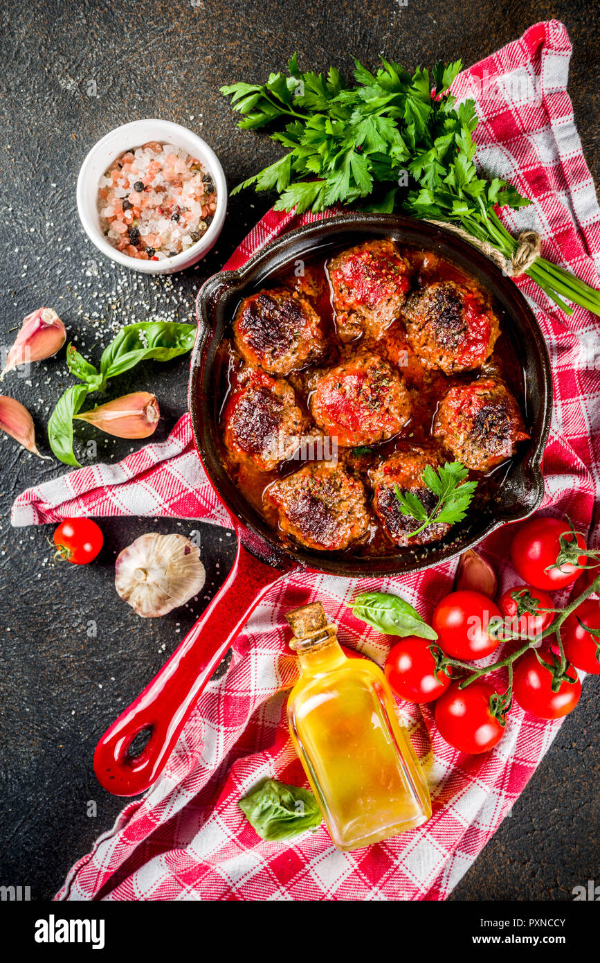 Homemade baked meatballs with tomato sauce in small frying pan on dark ...