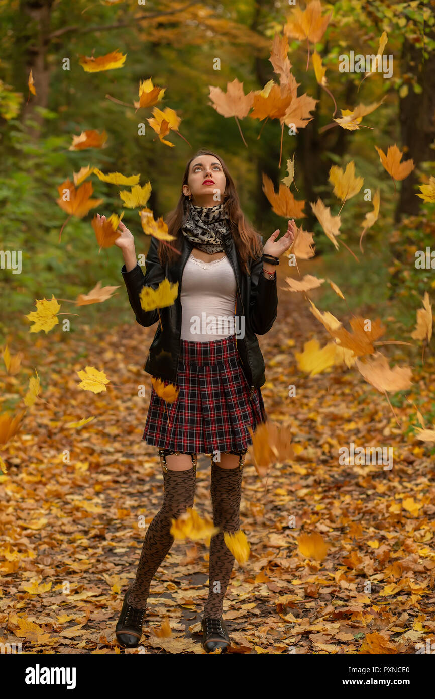 beautiful sad girl in autumn park plays with falling maple leaves Stock ...