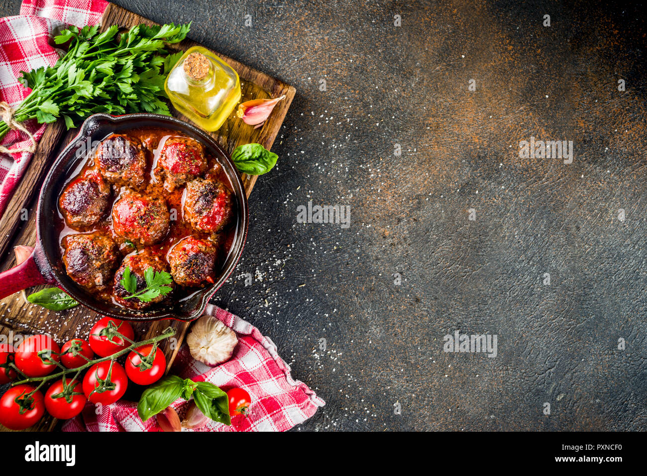 Homemade baked meatballs with tomato sauce in small frying pan on dark ...