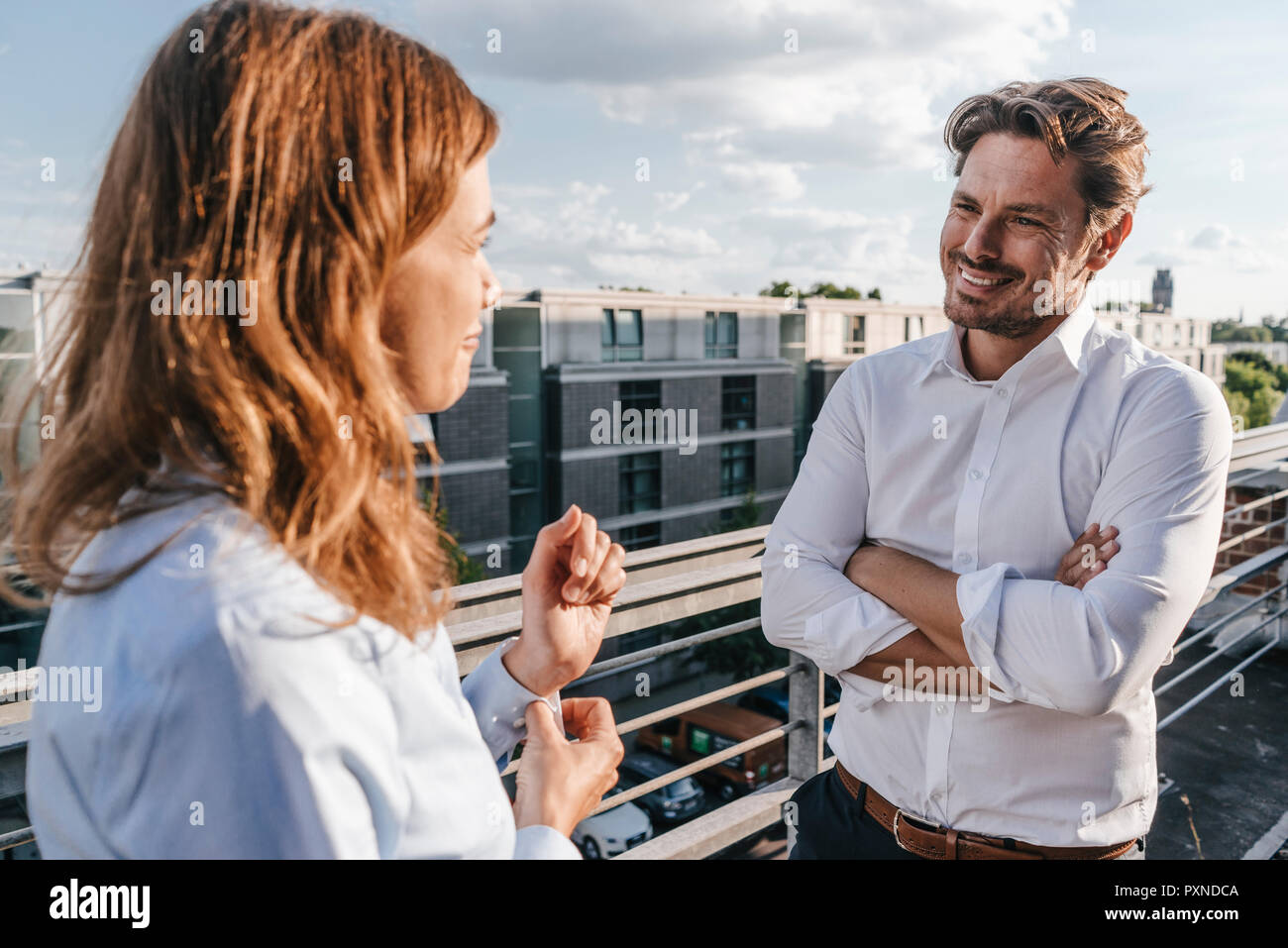 Business people standing on balcony, discussing Stock Photo - Alamy