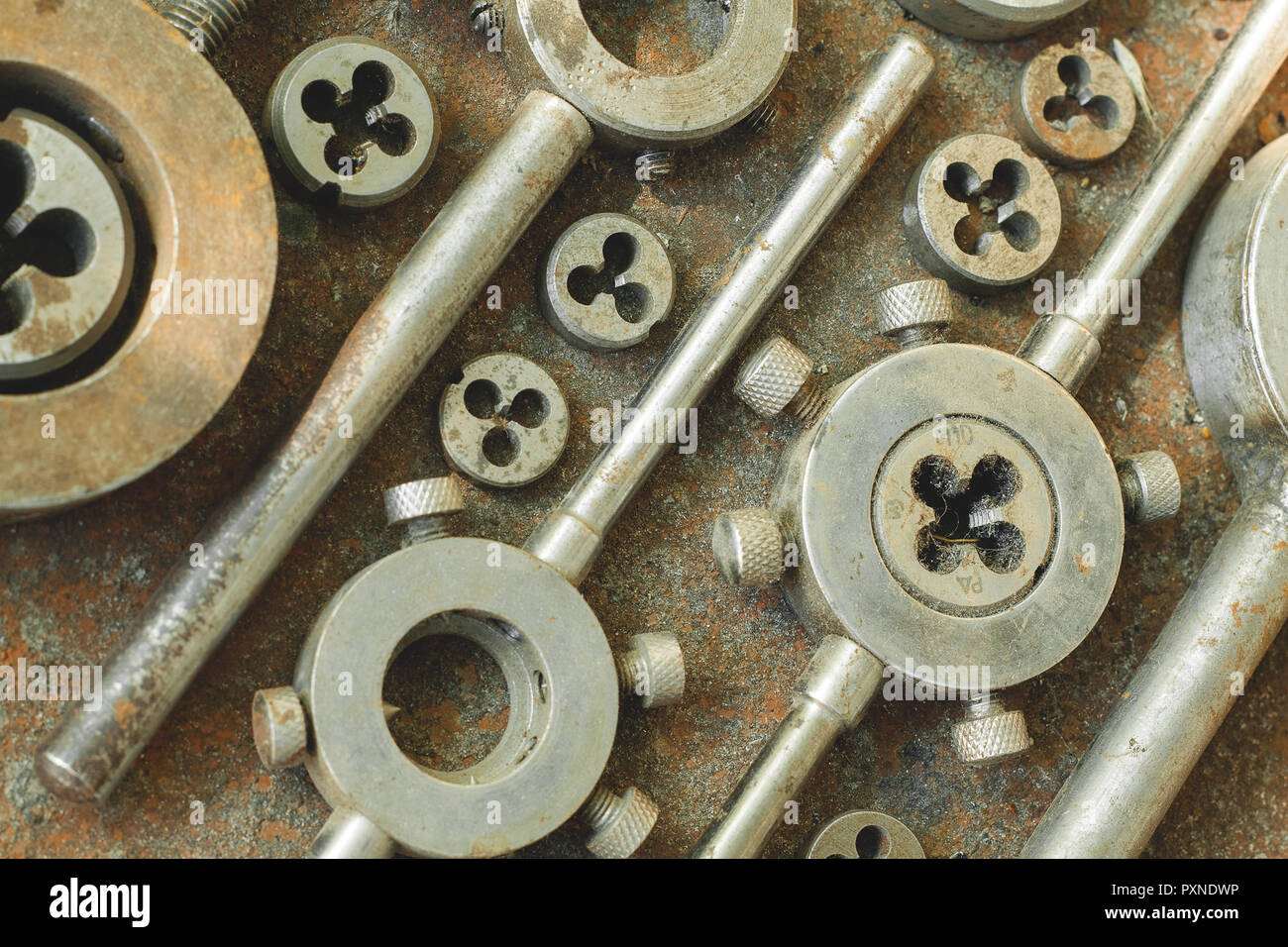 Threading dies on rusty metal surface close-up Stock Photo - Alamy