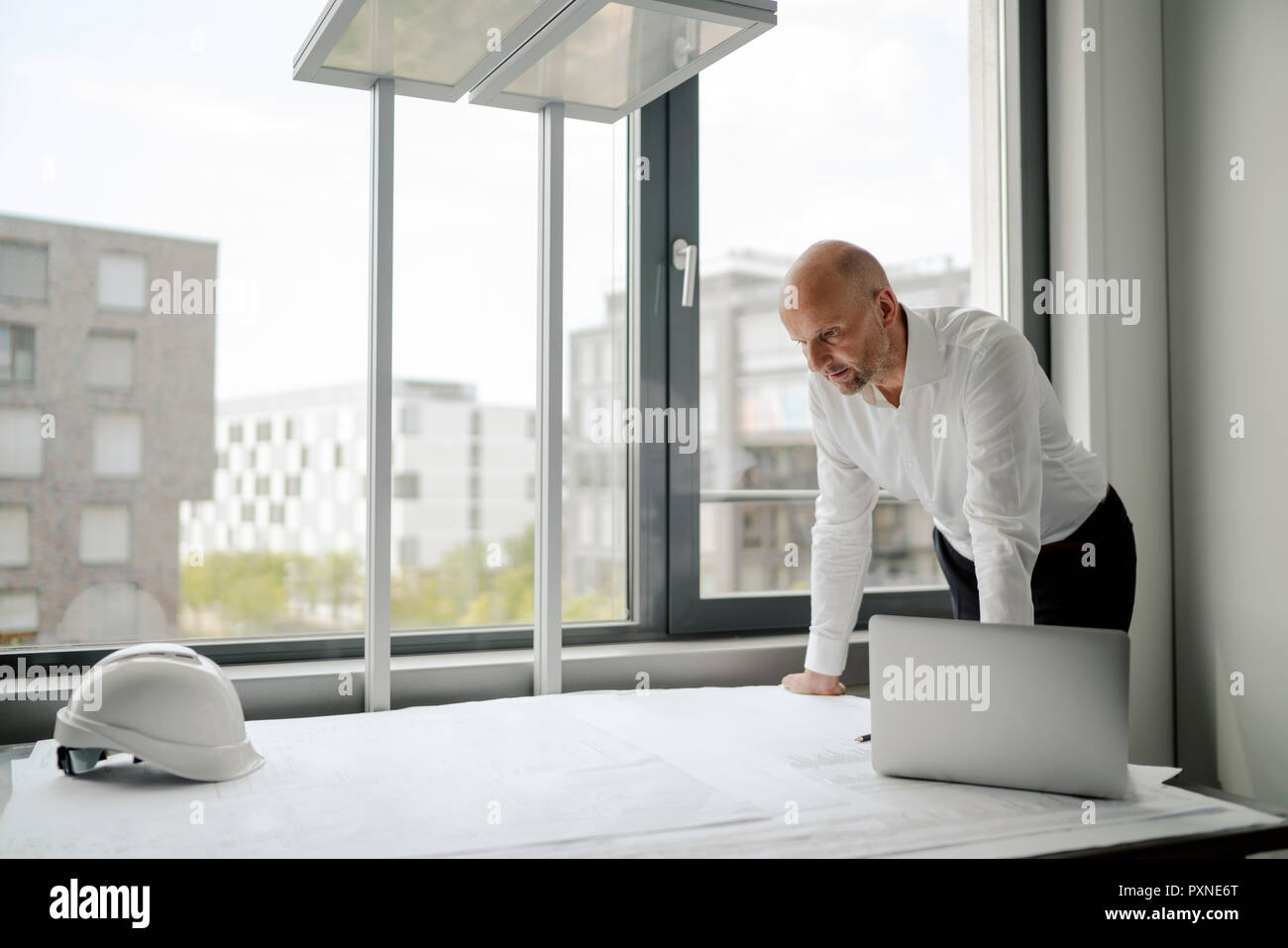 Engineer working in his office, using laptop Stock Photo - Alamy