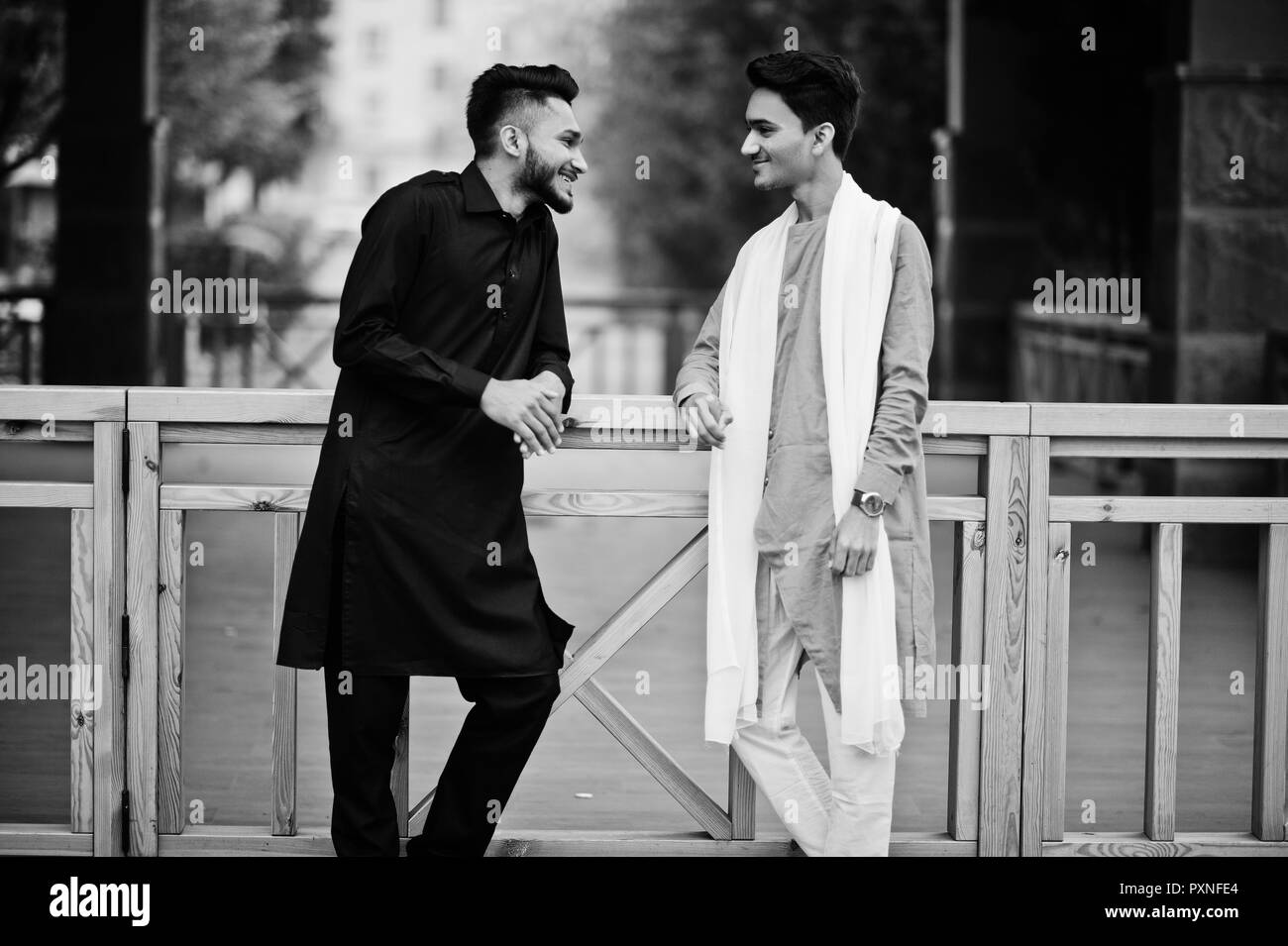 Two indian stylish mans friends in traditional clothes posed outdoor ...