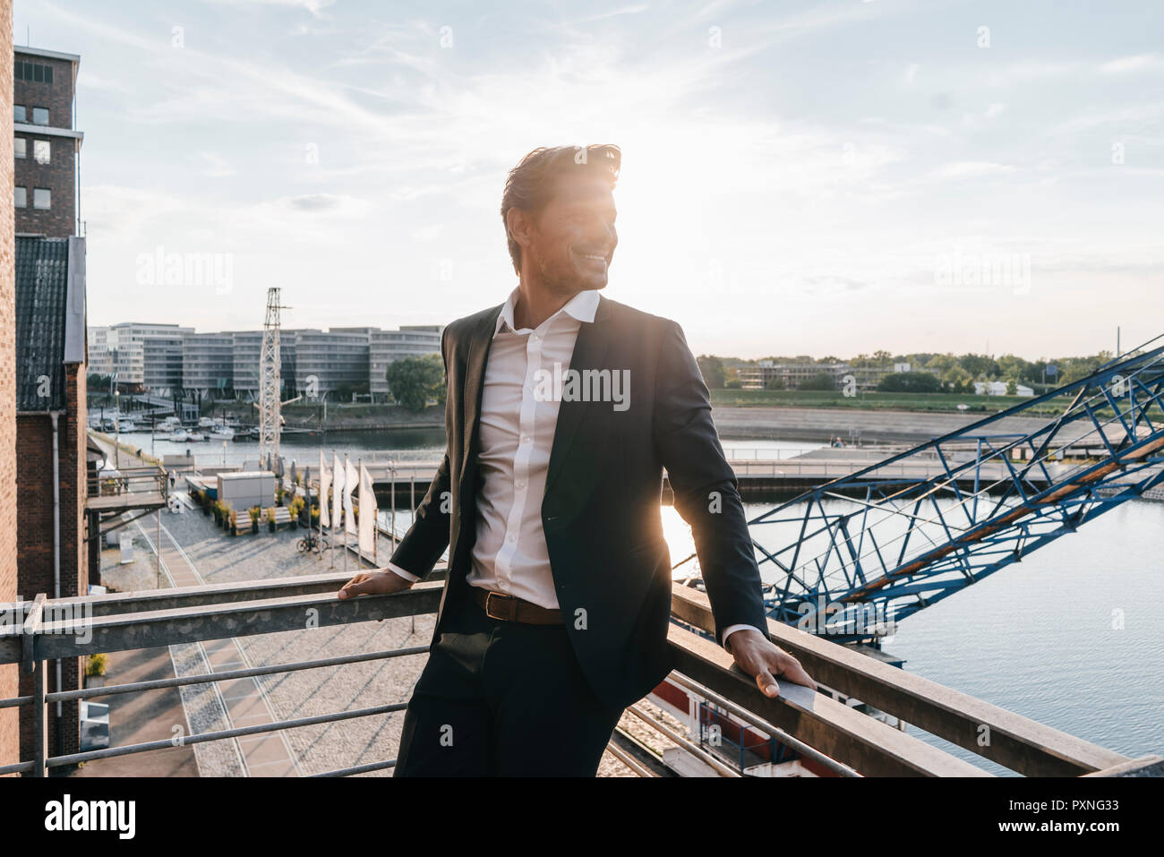 Successful businessman standing on balcony Stock Photo - Alamy