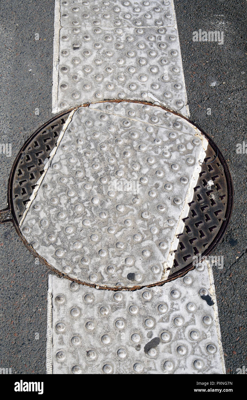 Manhole cover, which has had a tactile paving, to assist the blind ...
