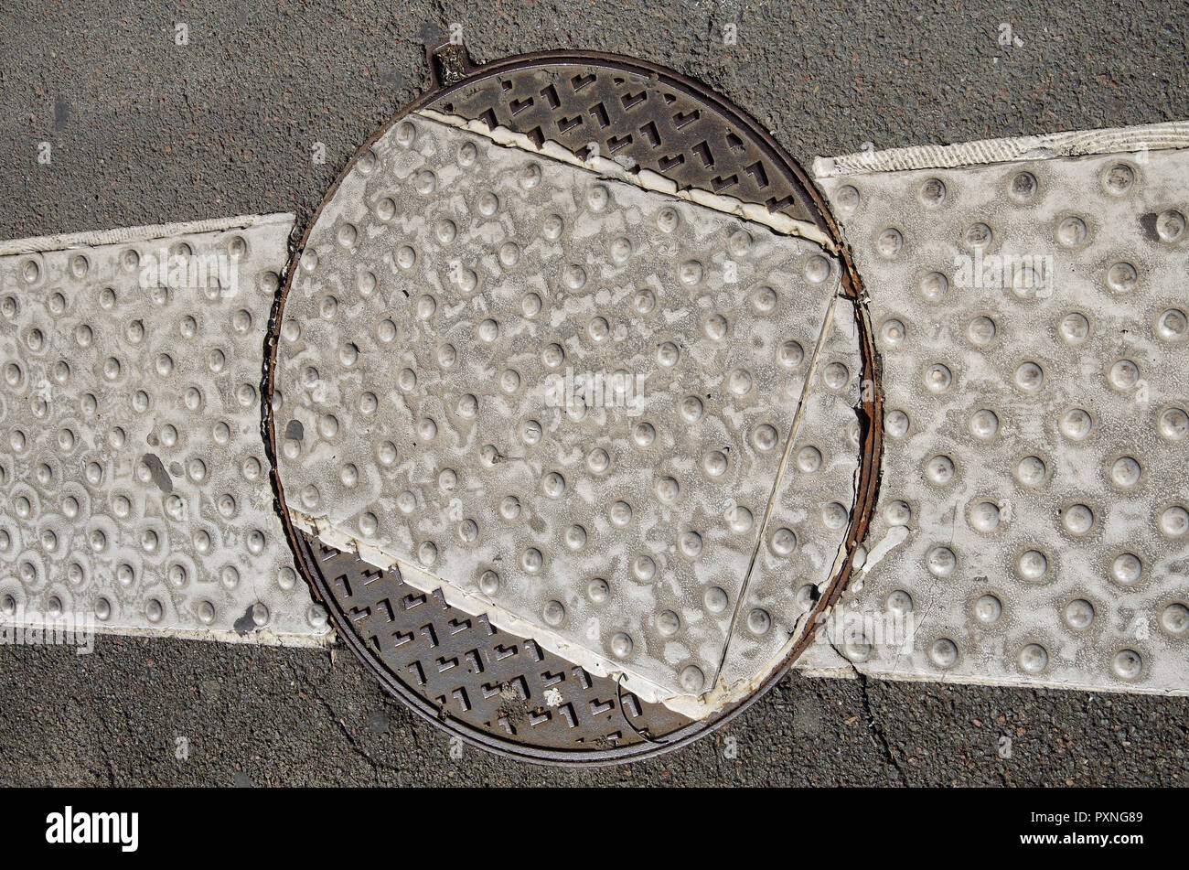 Manhole cover, which has had a tactile paving, to assist the blind ...