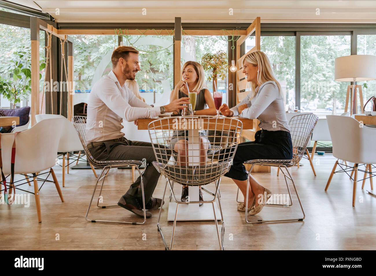 Three friends meeting in a cafe Stock Photo - Alamy