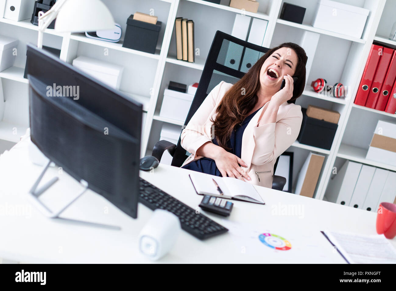 Beautiful girl working in a bright office. The girl is dressed in a ...